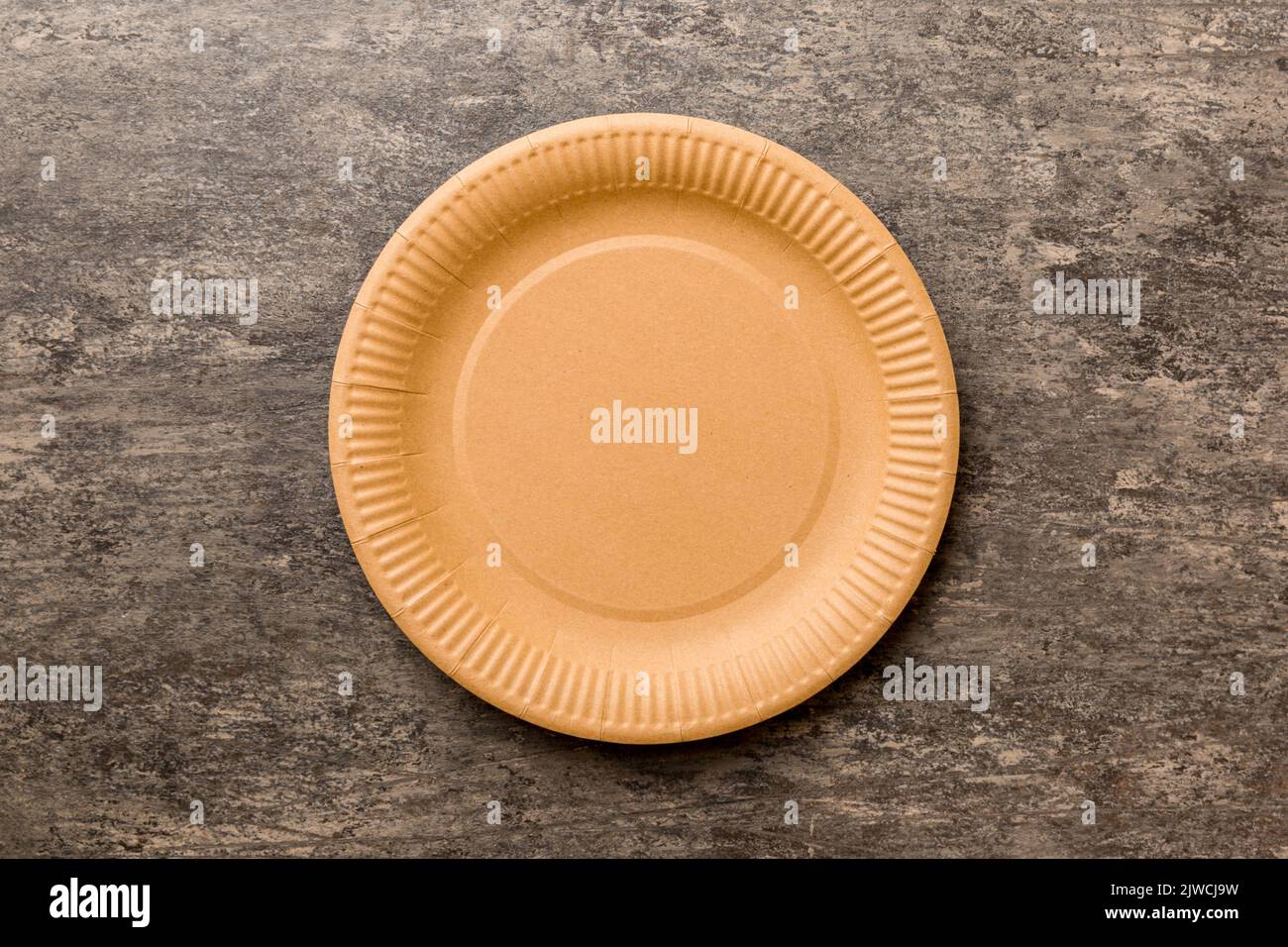 Perspective view of eco paper plate on cement background. Empty space ...