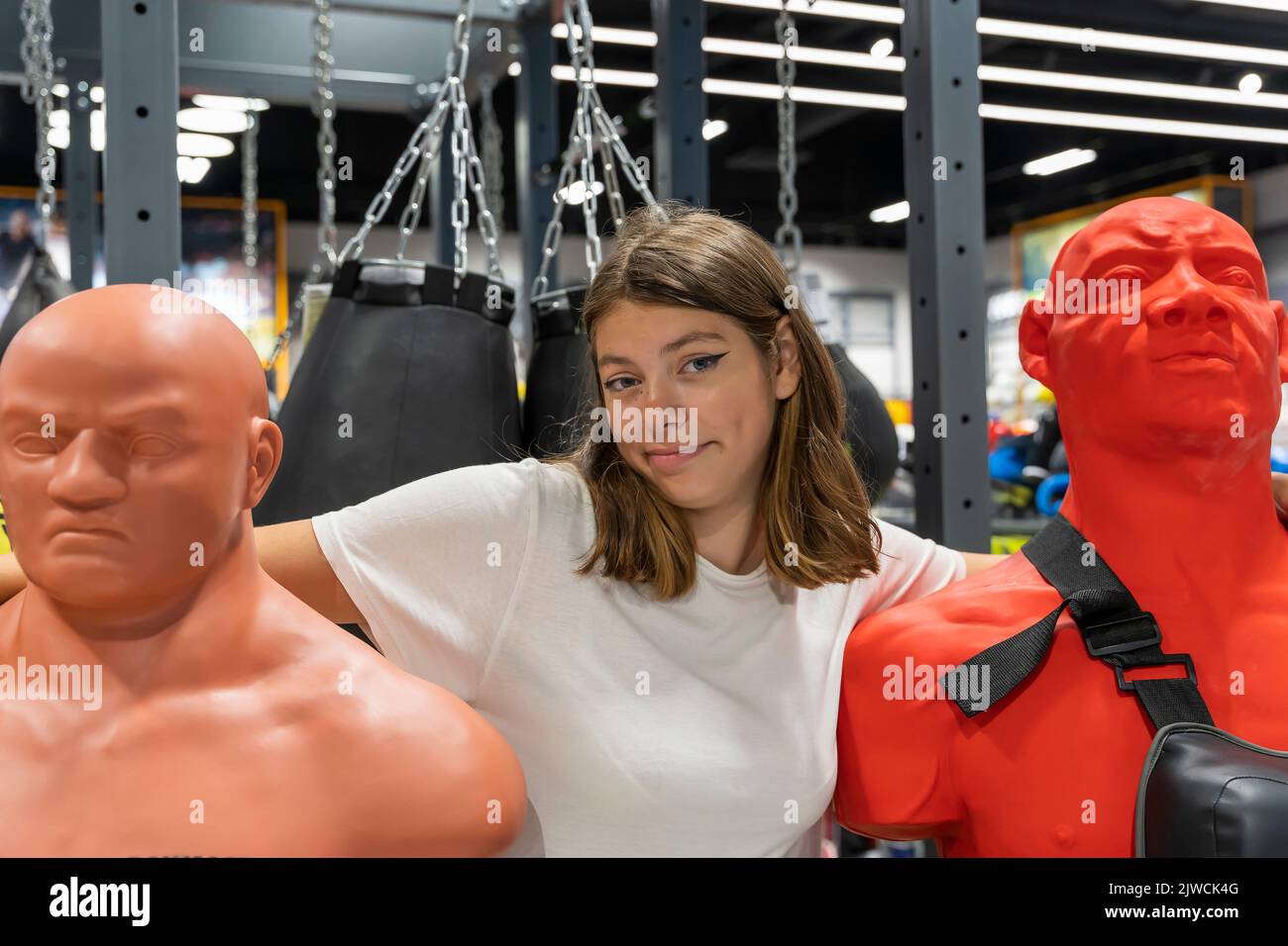 cute teenage girl hugs two rubber boxing dummies. extreme sports Stock ...