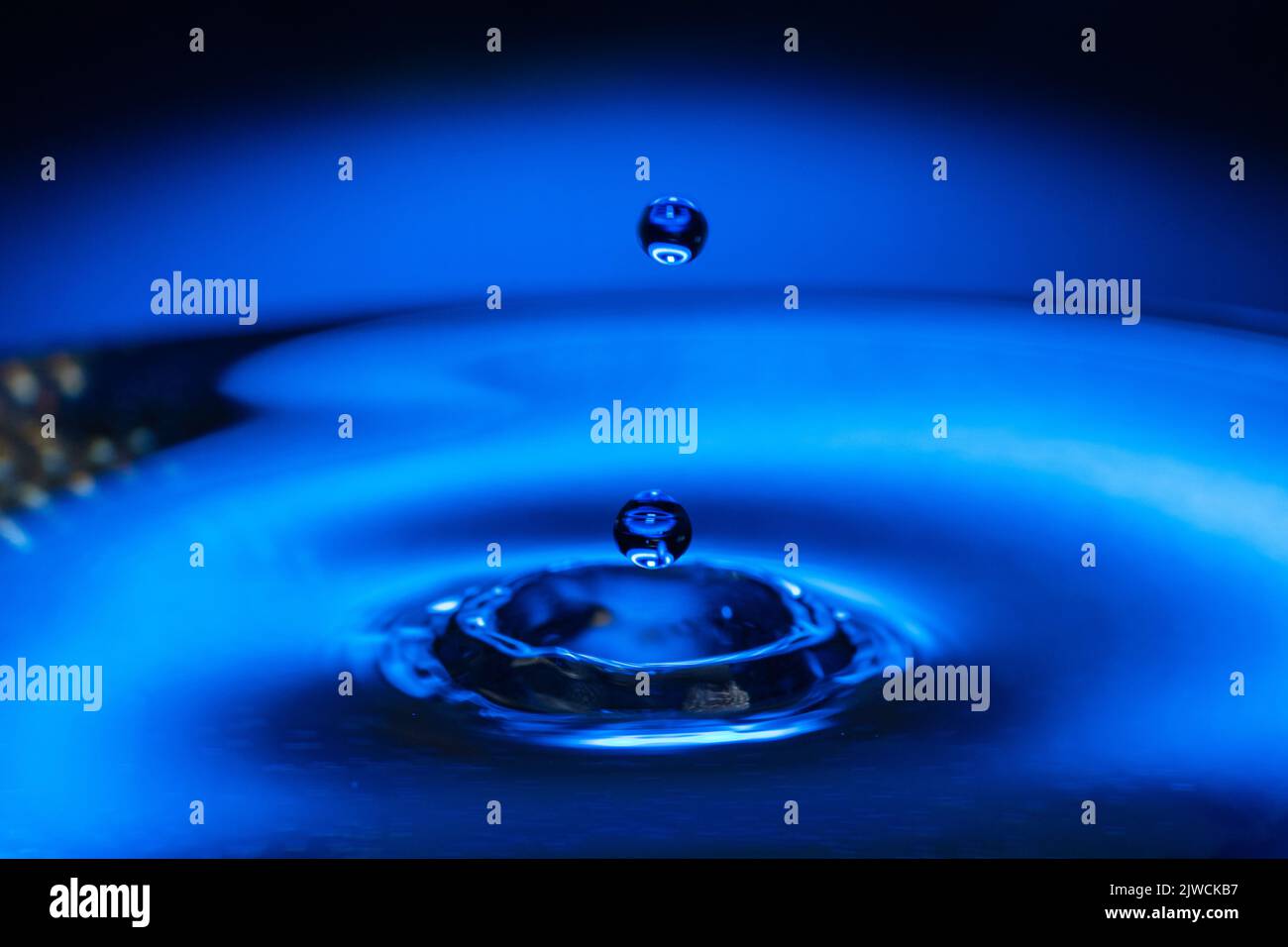Macro water drop on a blue background and circles on it. Round water ...