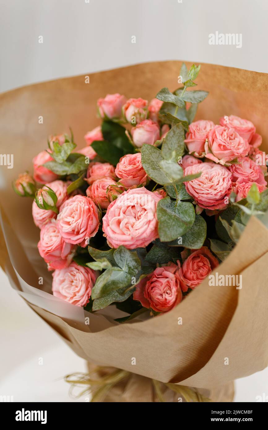 Pink spray roses with sprigs of green eucalyptus stacked together in ...