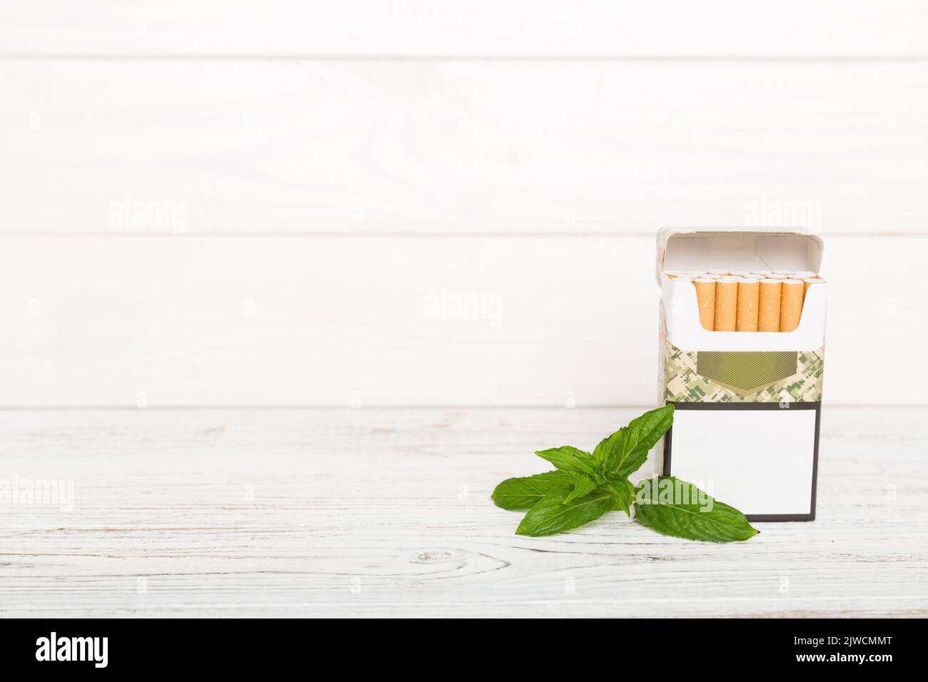 Pack of menthol cigarettes and fresh mint on colored table, Menthol ...