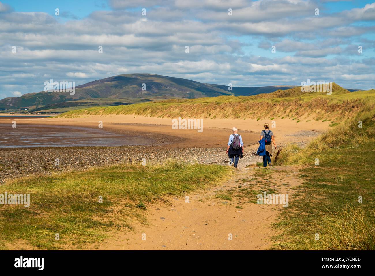 Two women walking on the sandy beach at Sandscale Haws with Black ...