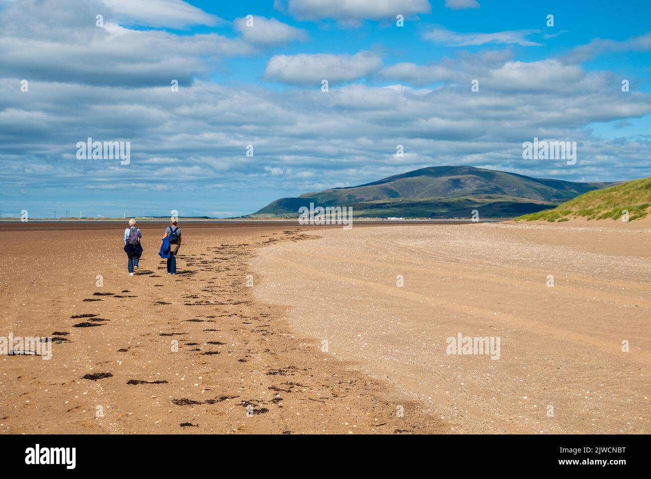 Two women walking on the sandy beach at Sandscale Haws Nature Reserve ...