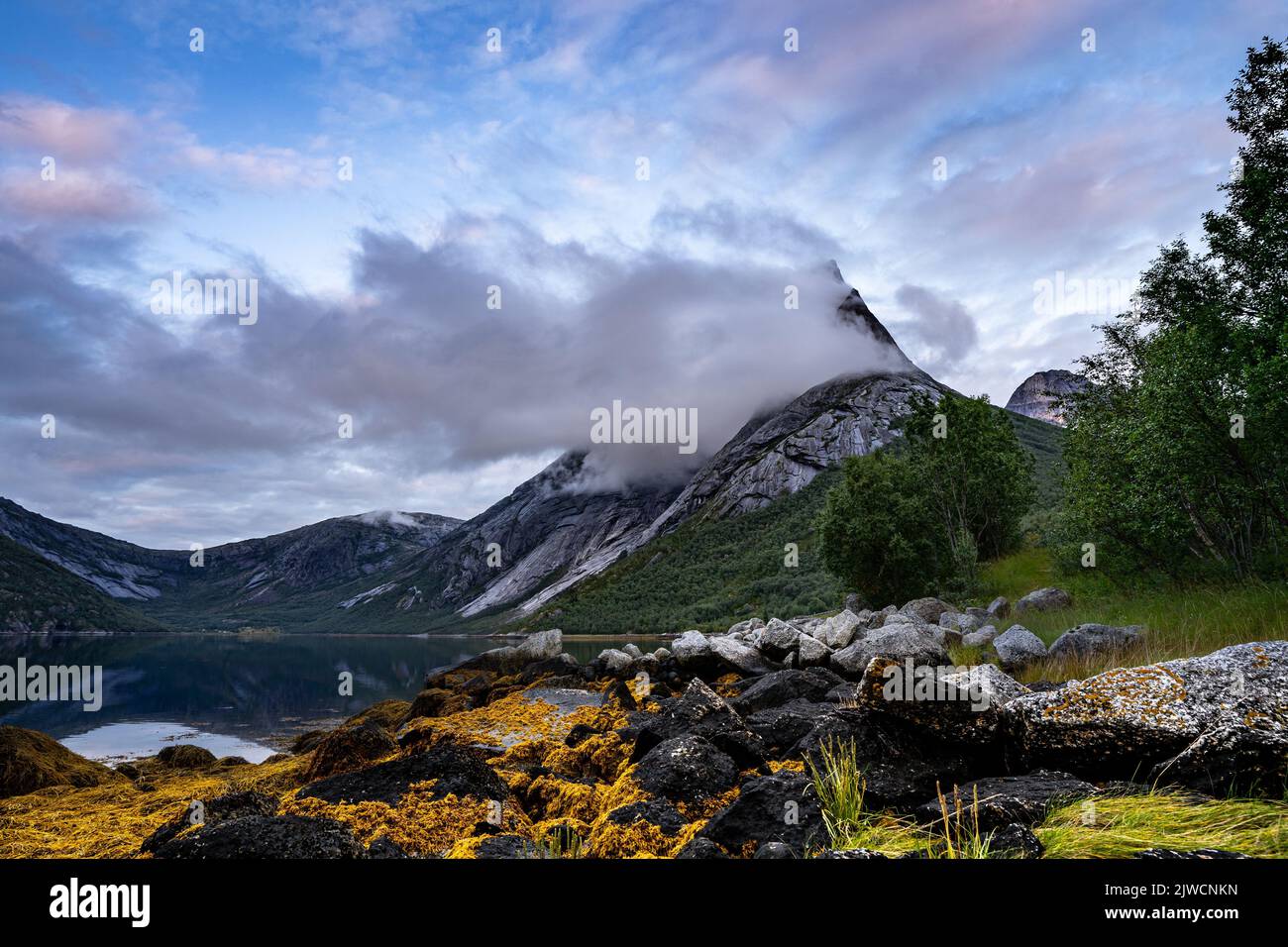 The beautiful landscape with a lake and Stetind mountain covered with ...