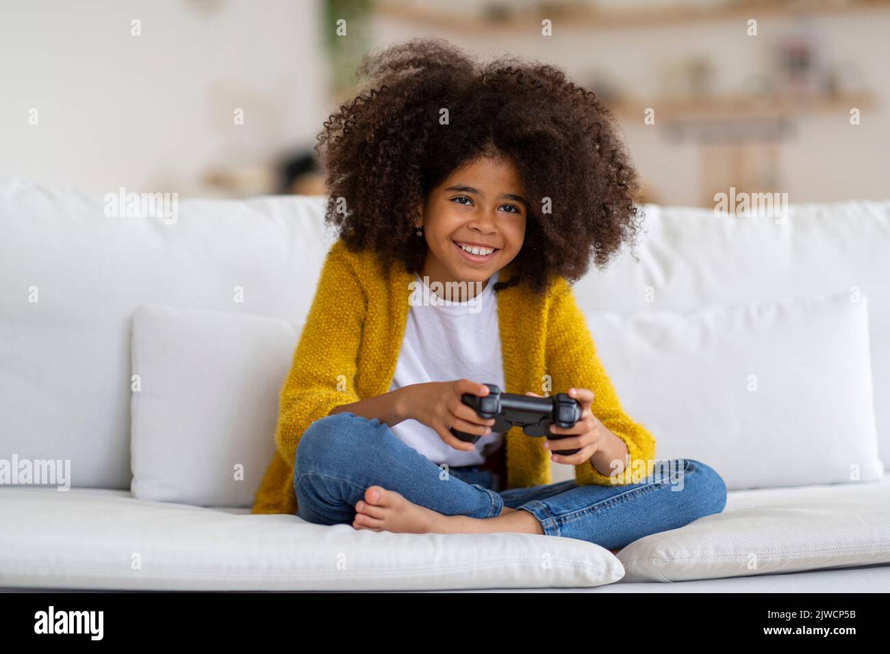 Happy preteen african american kid girl playing video game Stock Photo ...