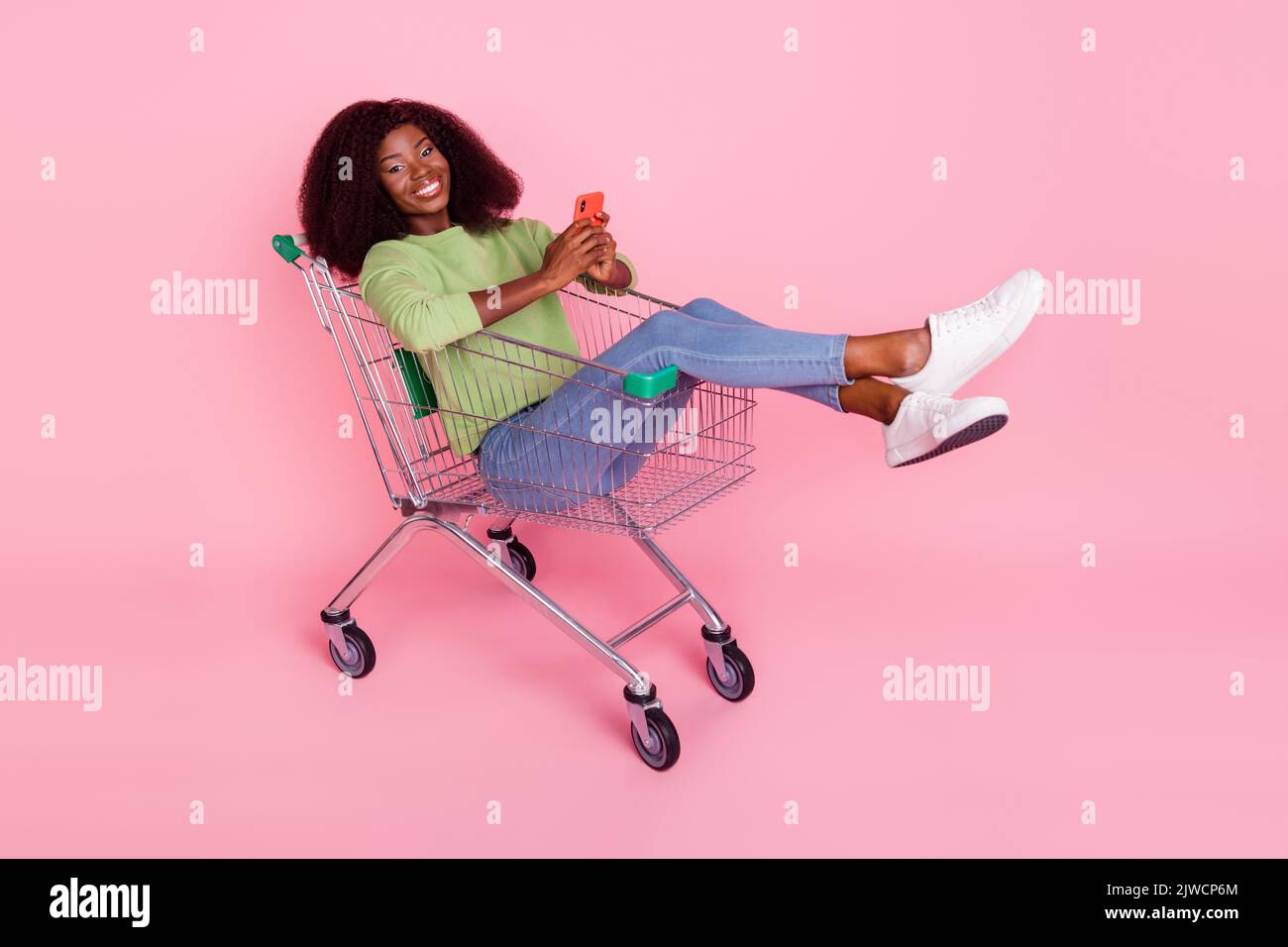 Full length photo of shiny charming girl dressed green pullover typing ...