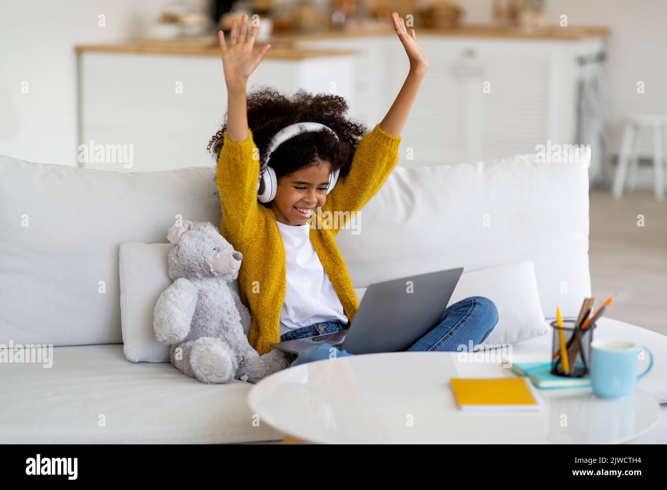 Emotional little black girl with wireless headset using notebook Stock ...