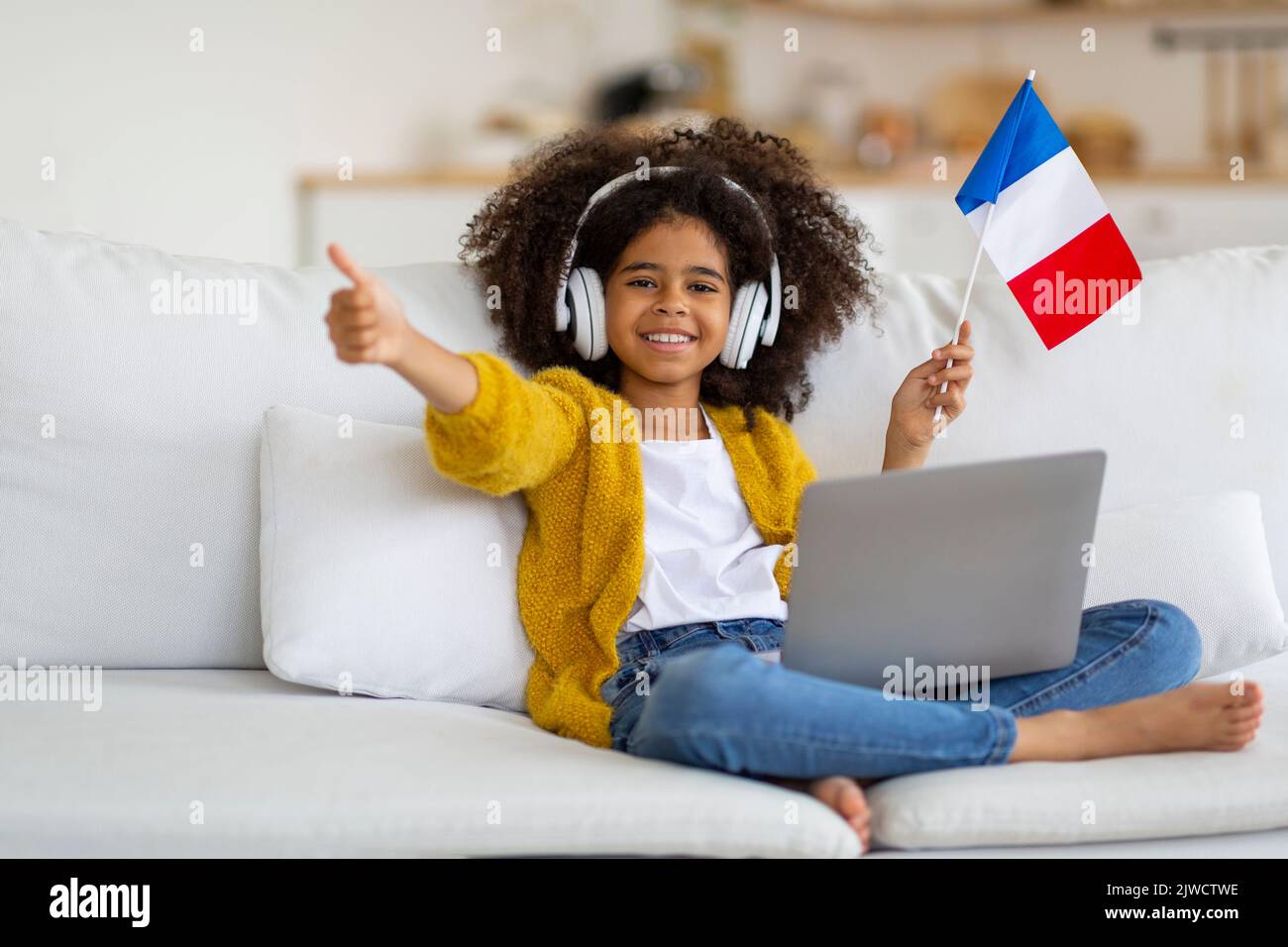 Happy black girl using laptop, showing French flag Stock Photo - Alamy