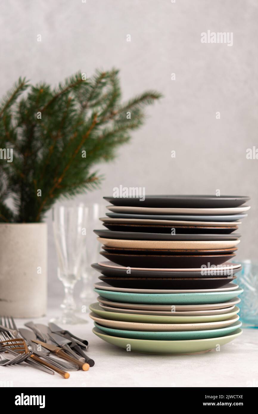 Preparing for a festive table setting, a stack of different plates and ...