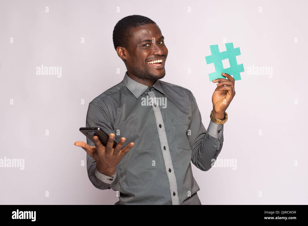 excited black man holding phone and hash tag symbol Stock Photo - Alamy