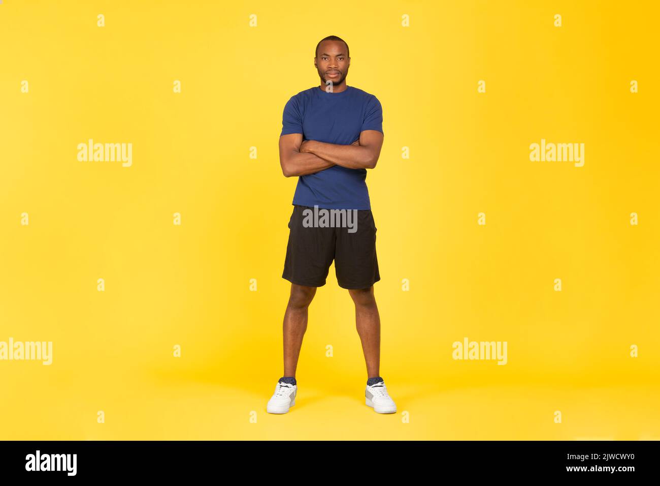 Determined African American Sportsman Crossing Hands On Yellow Studio ...