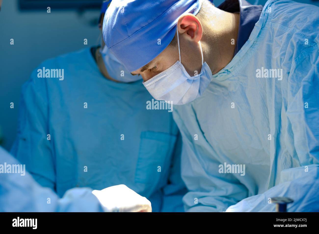 Close-up of the surgeon's face, leaning over the operating table ...