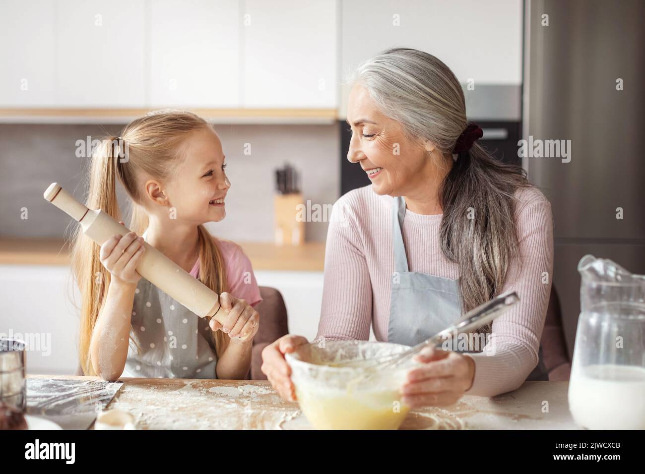 Cooking lesson. Smiling european little granddaughter and old grandma ...