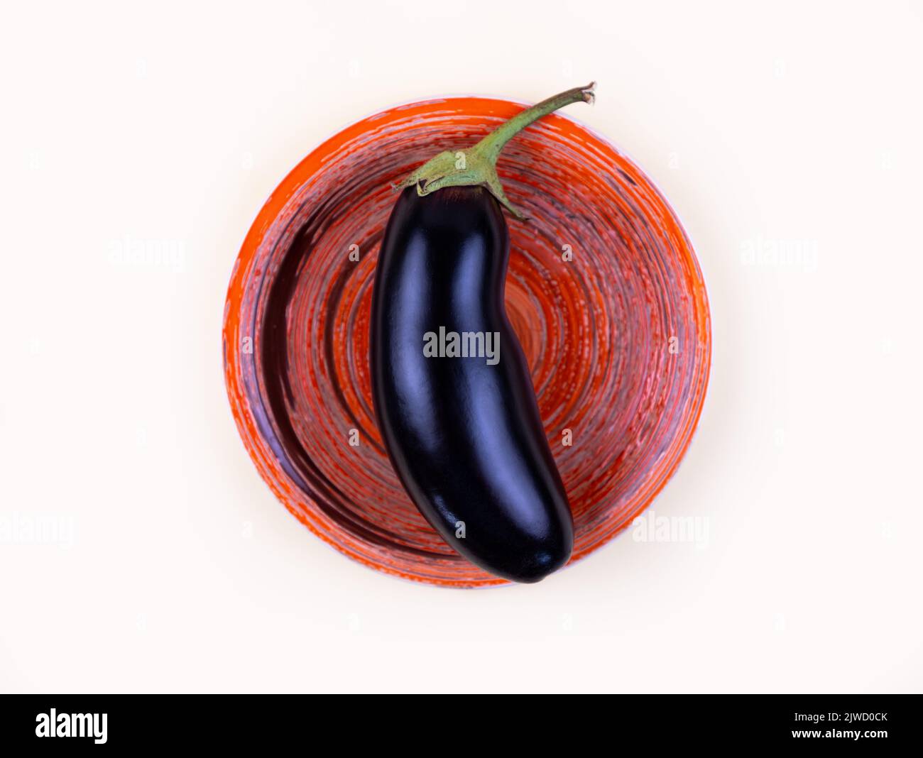 Purple eggplant on an orange plate. Complementary colors trendy still ...