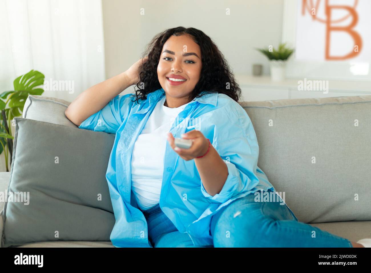 African American Lady Watching Television Pointing Remote Controller At ...