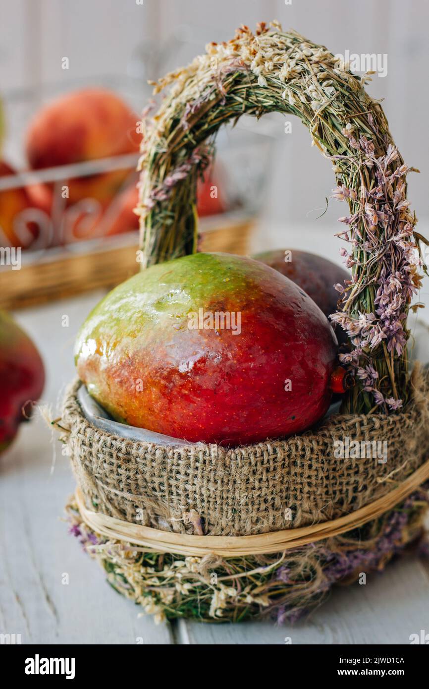 Fresh ripe mango in a basket over a white table Stock Photo - Alamy