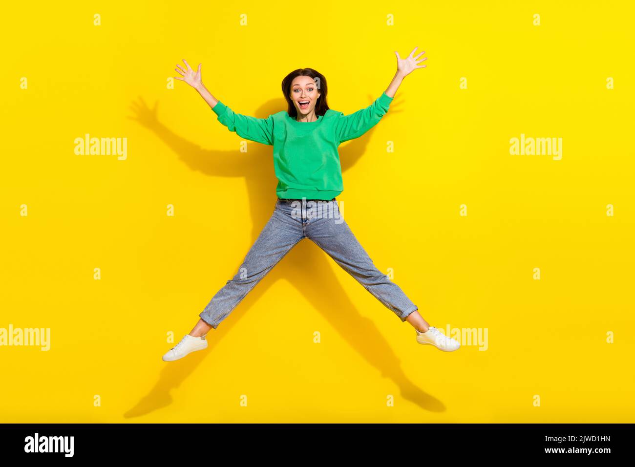 Full size photo of overjoyed pretty girl jumping raise hands make star ...