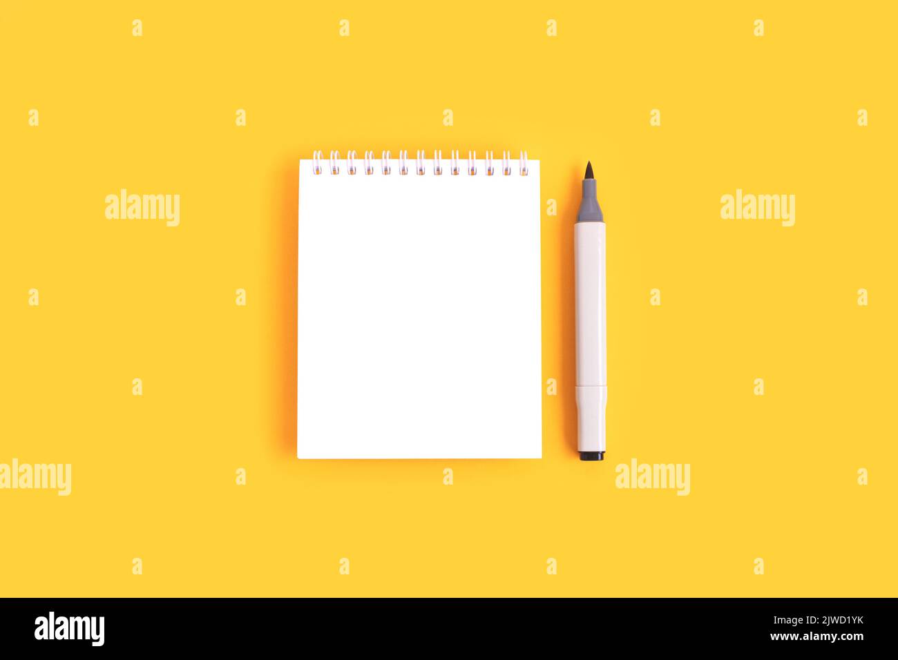Clean notepad mockup and felt tip pen on a yellow background. Empty ...