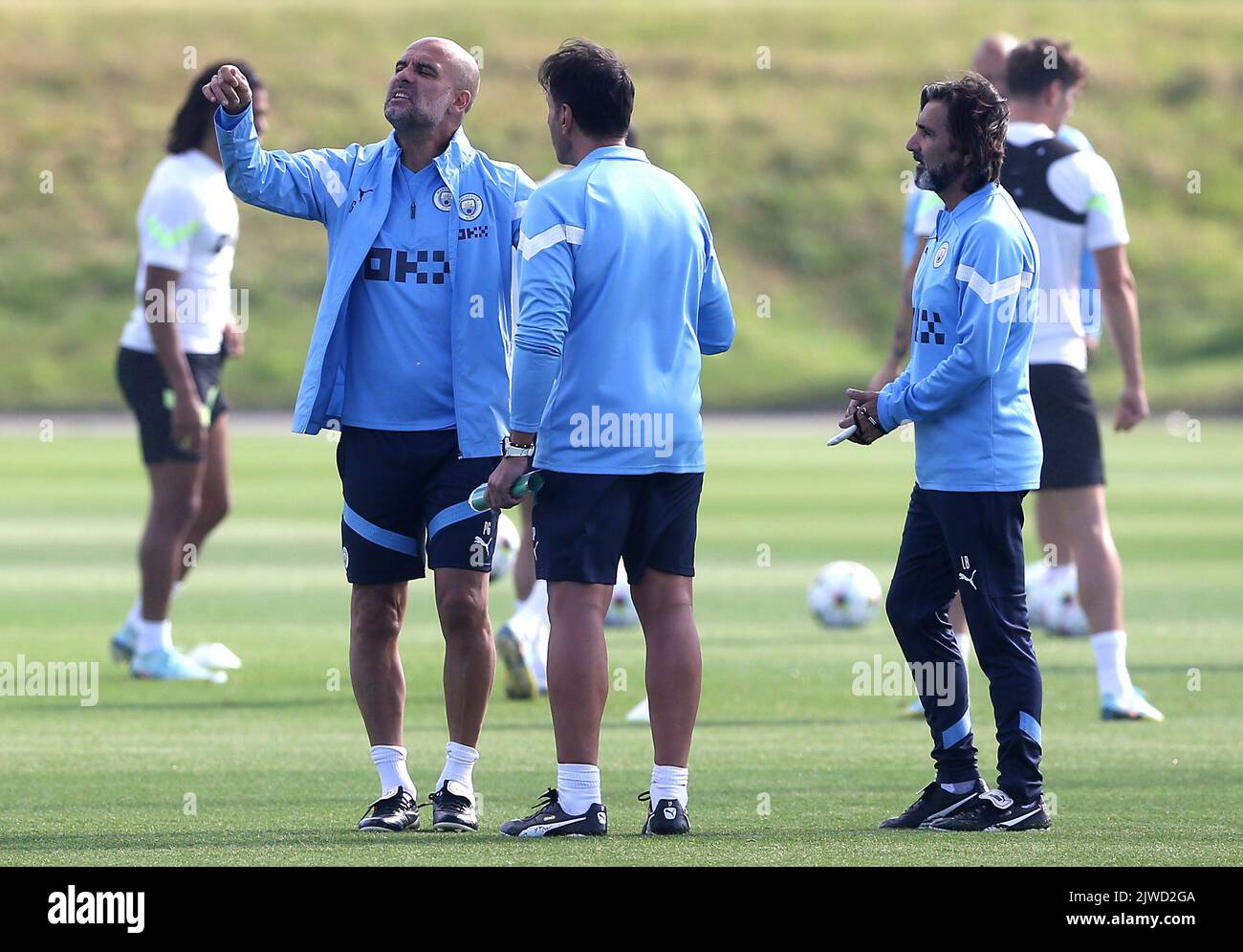 Manchester City manager Pep Guardiola (left) speaks to his backroom ...