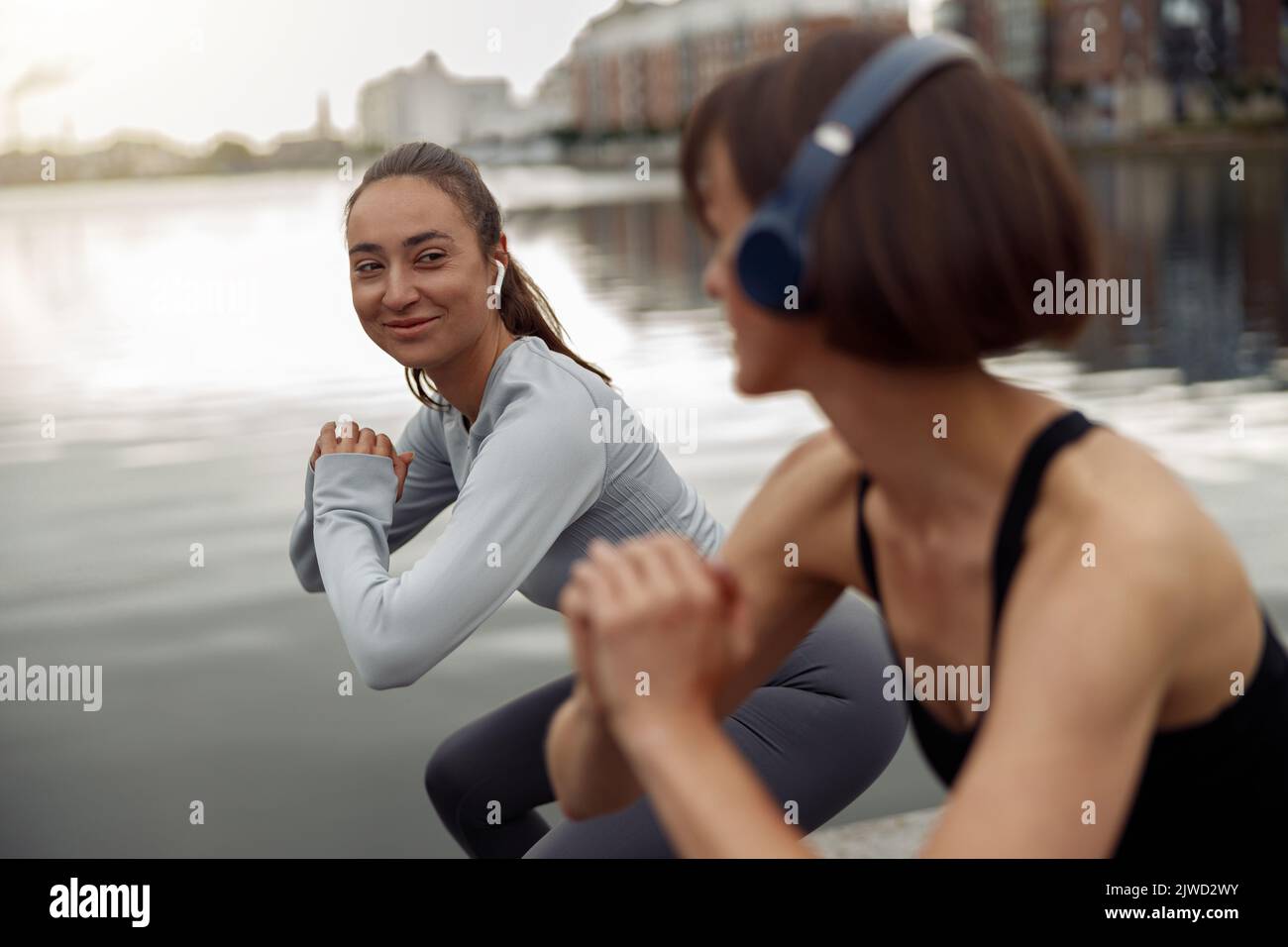 Beautiful sportive women doing fitness exercise on city background and ...