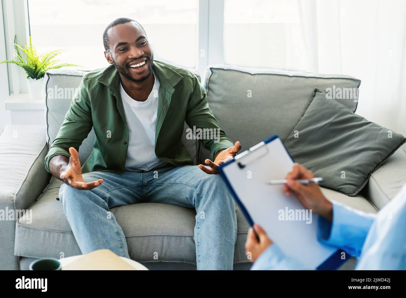 Effective psychotherapy. Happy black man talking to psychologist ...