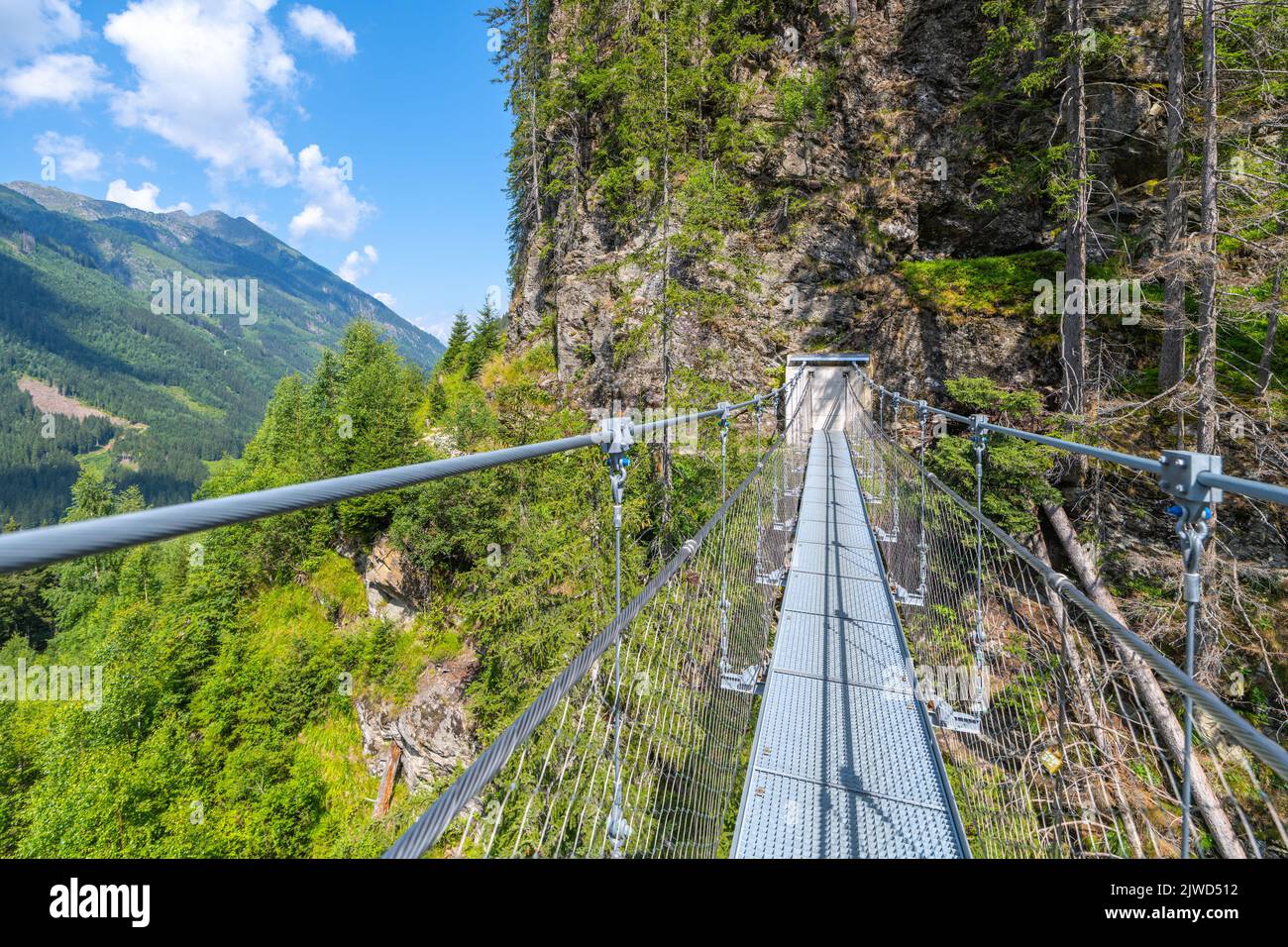 Simple suspension footbridge over mountain valley Stock Photo - Alamy
