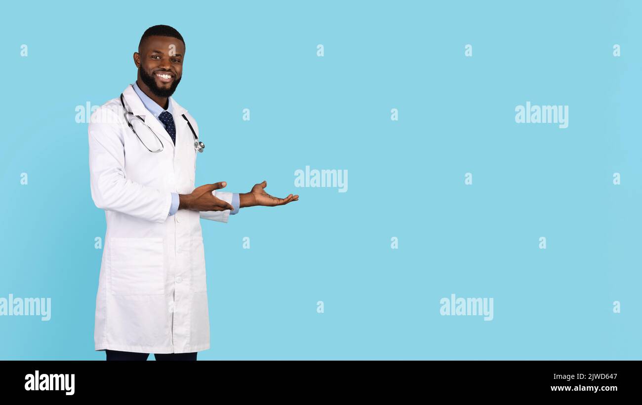 Medical Ad. Smiling black male doctor pointing aside at copy space ...