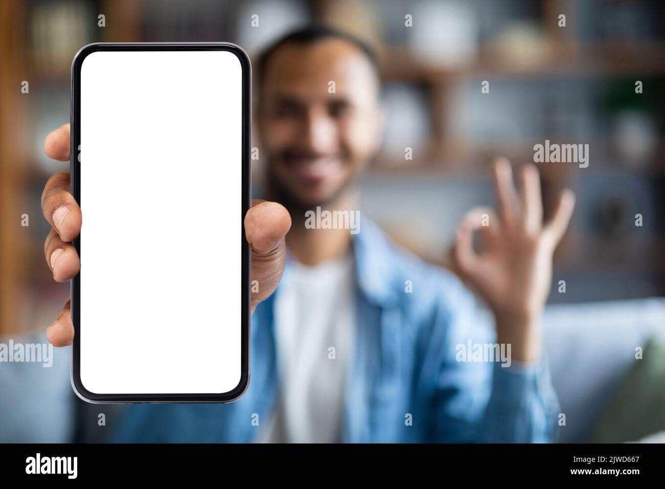Mobile Offer. Smiling black man demonstrating big smartphone with blank ...