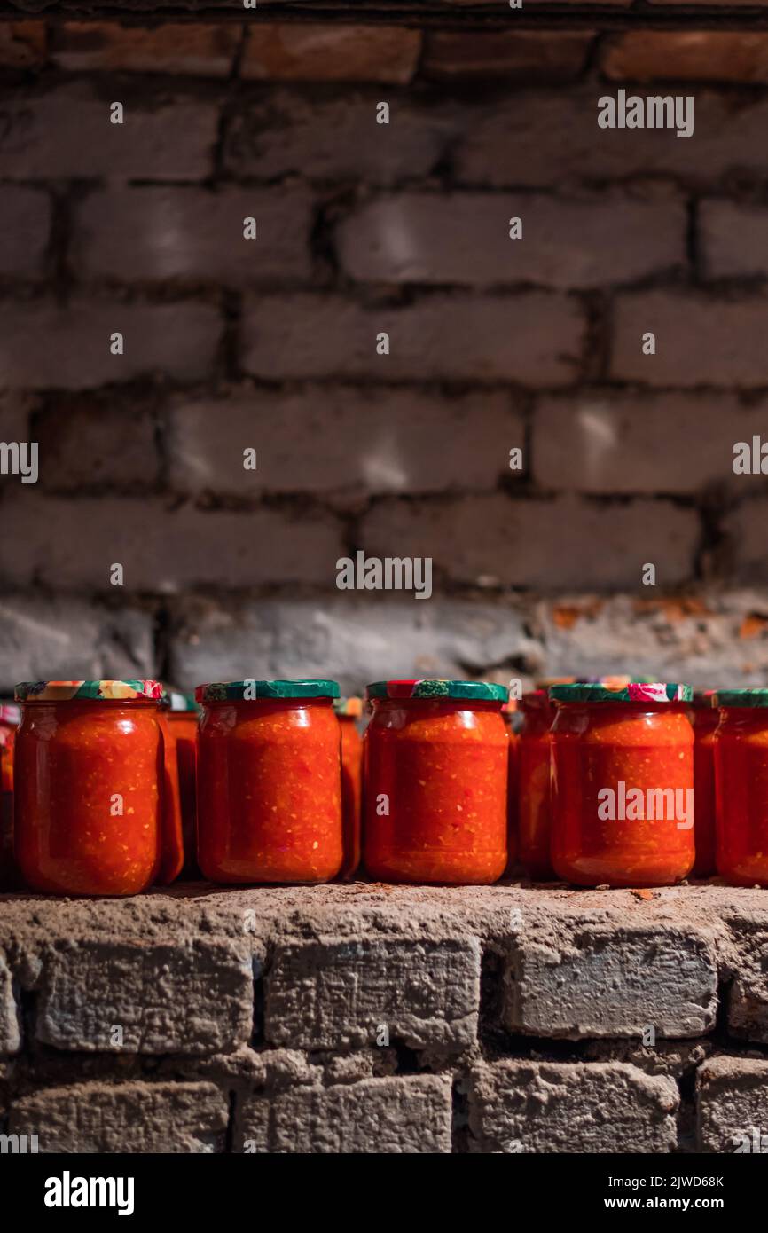 Canned food on a brick shelf in a bomb shelter. food supplies in glass ...