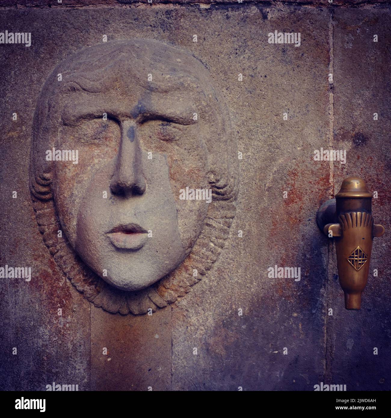 Carved sculptural face and brass vintage water fountain tap Stock Photo ...