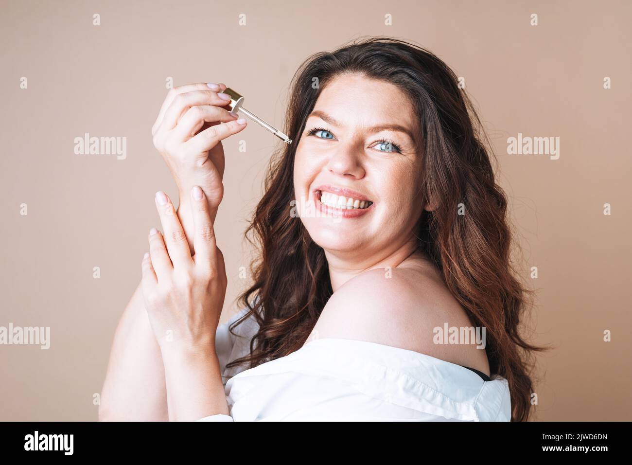 Beauty portrait of body positive woman with dark hair with pipette with ...