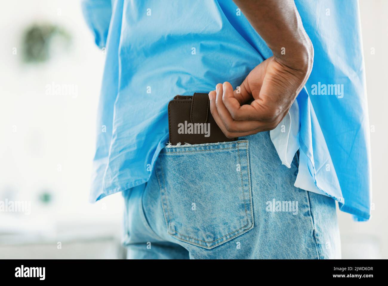Rear view of african american man keeping wallet in back pocket of his ...