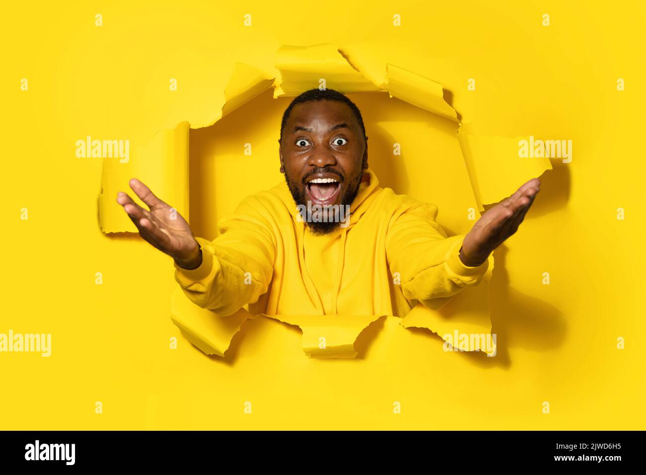 Excited african american man spreading hands sideways, looking at ... Excited african american man spreading hands sideways, looking at ...
