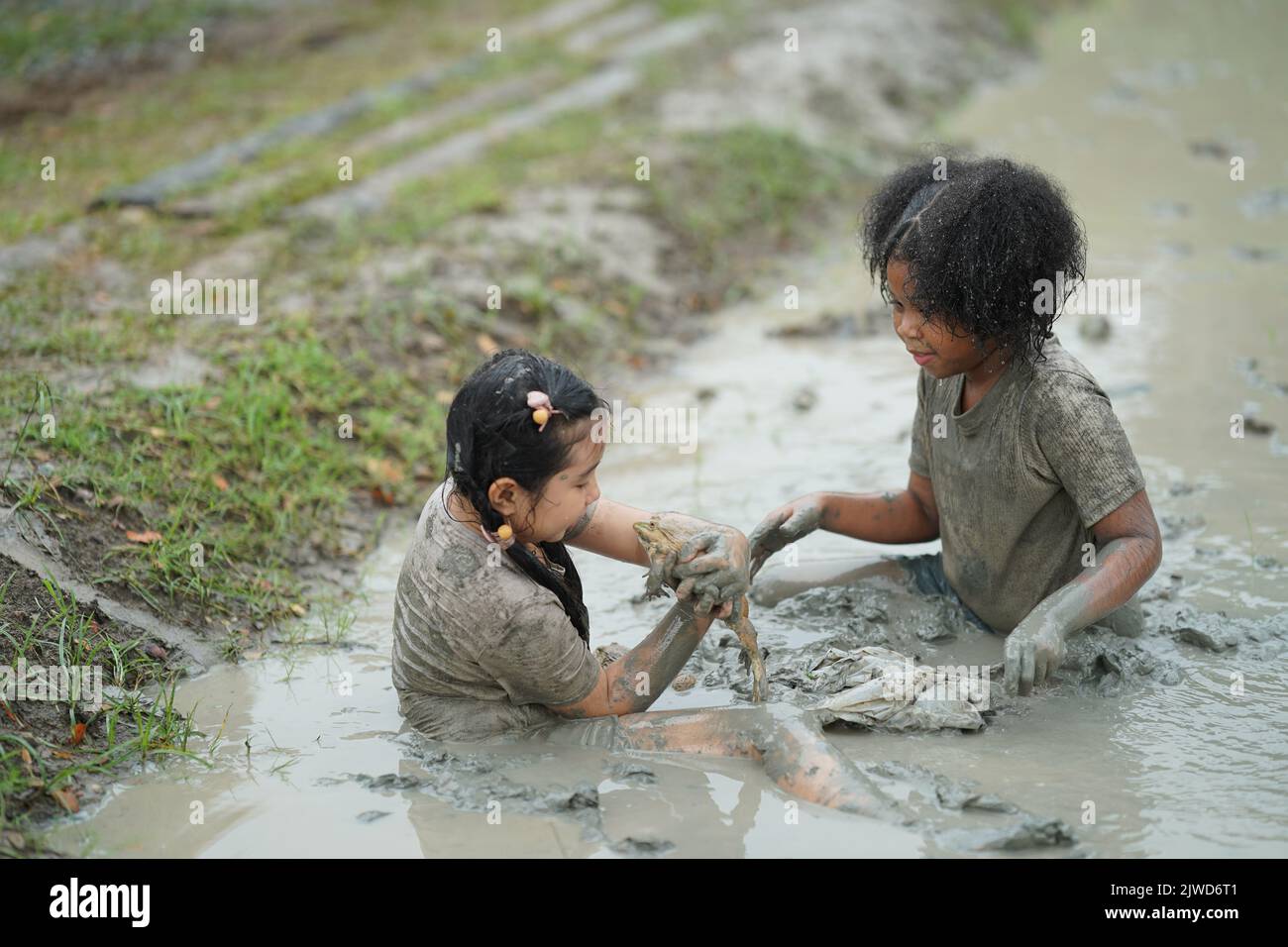 Group of kids playing on muck in the raining day Stock Photo - Alamy