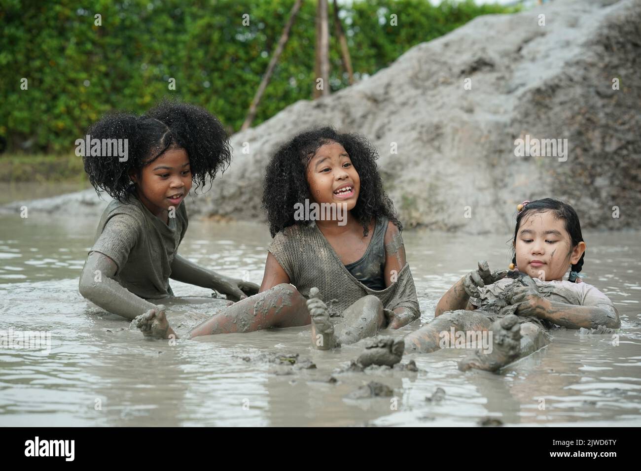 Group of kids playing on muck in the raining day Stock Photo - Alamy