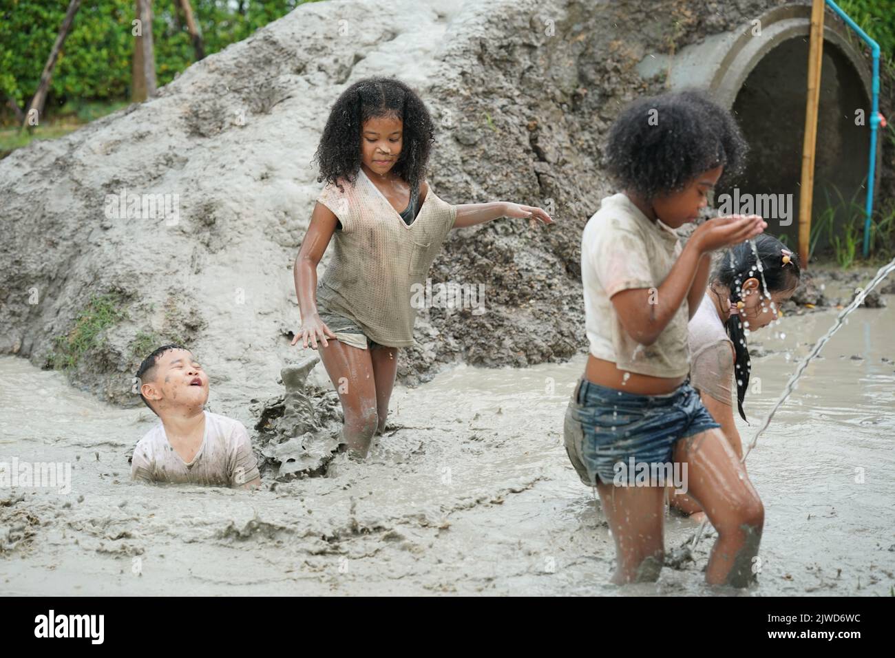 Group of kids playing on muck in the raining day Stock Photo - Alamy