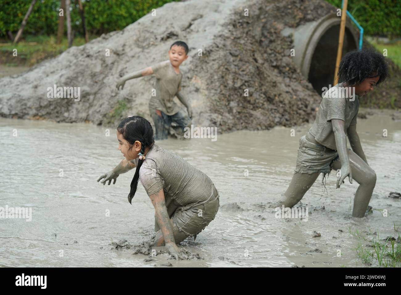 Group of kids playing on muck in the raining day Stock Photo - Alamy