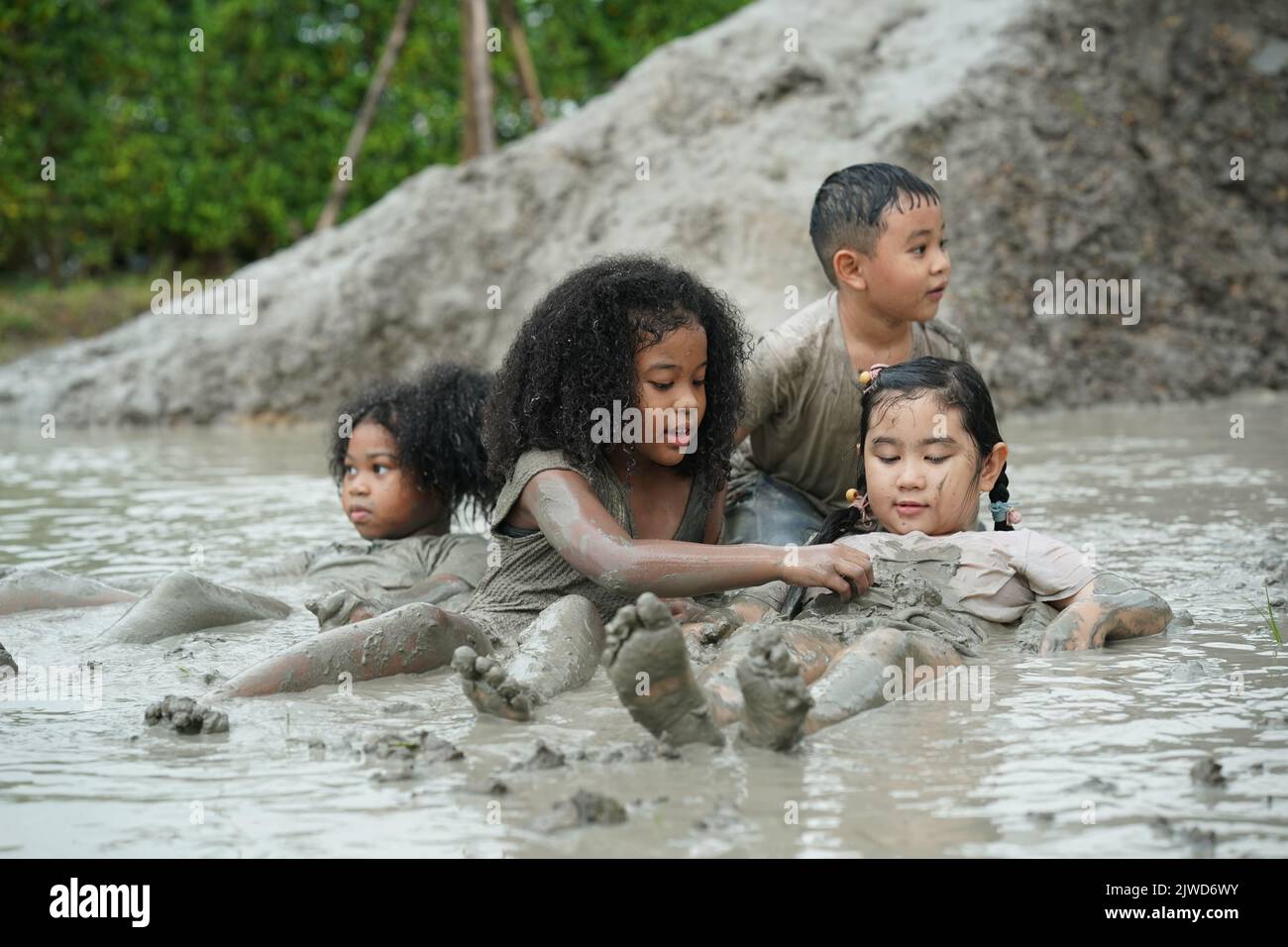 Group of kids playing on muck in the raining day Stock Photo - Alamy