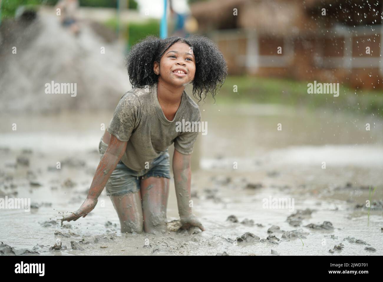 Group of kids playing on muck in the raining day Stock Photo - Alamy