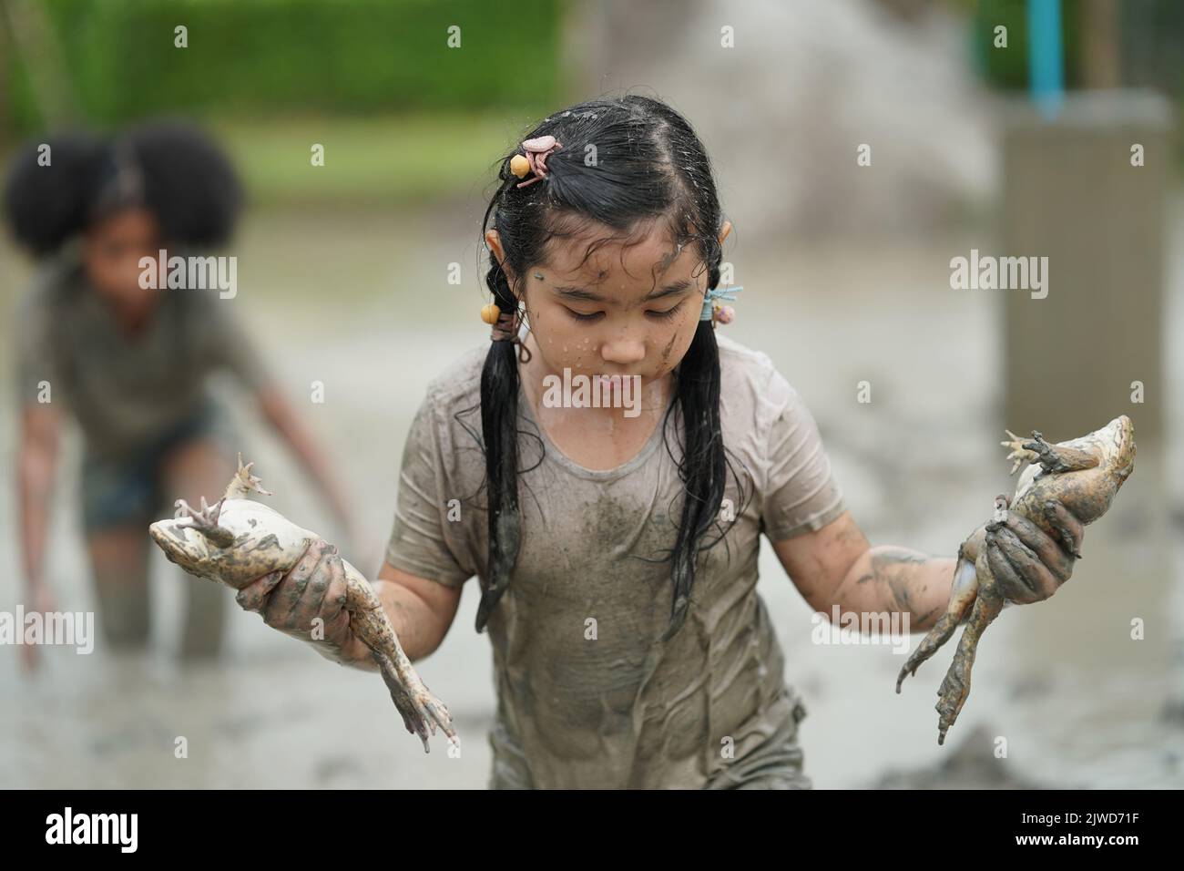 Group of kids playing on muck in the raining day Stock Photo - Alamy