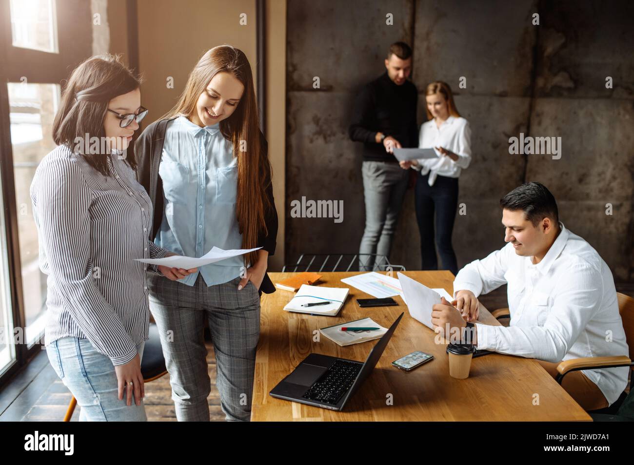 Teamwork. A team of young smart people are discussing in groups in a ...