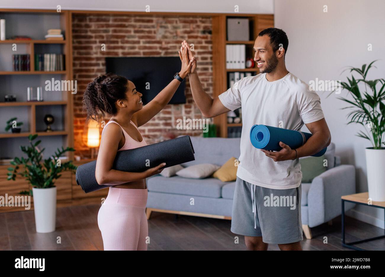 Cheerful young african american husband and wife in sportswear with ...