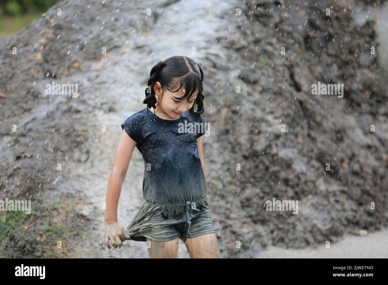 Group of kids playing on muck in the raining day Stock Photo - Alamy