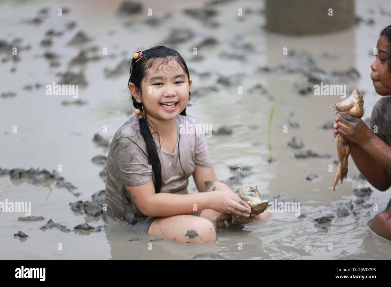 Group of kids playing on muck in the raining day Stock Photo - Alamy