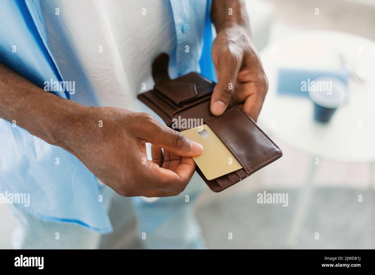Unrecognizable black guy taking out credit card from his wallet ...