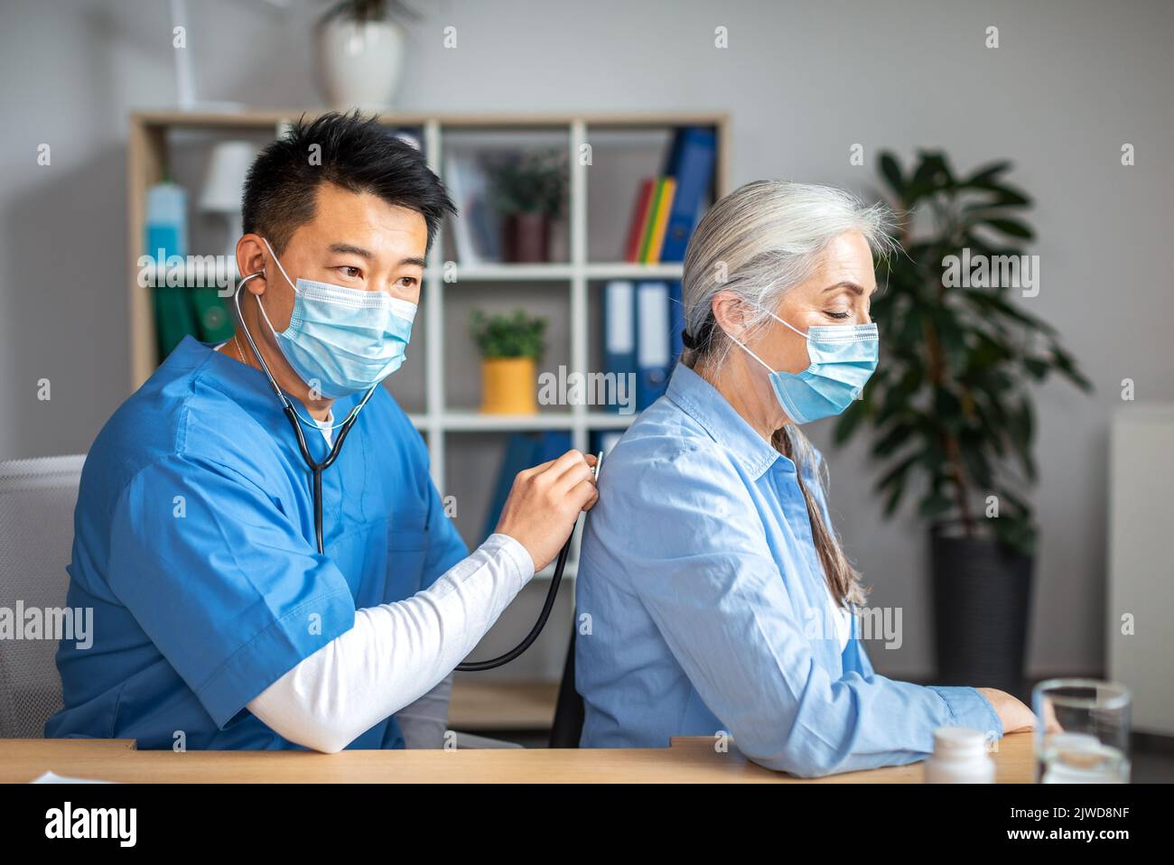 Concentrated millennial korean man doctor in protective mask with ...