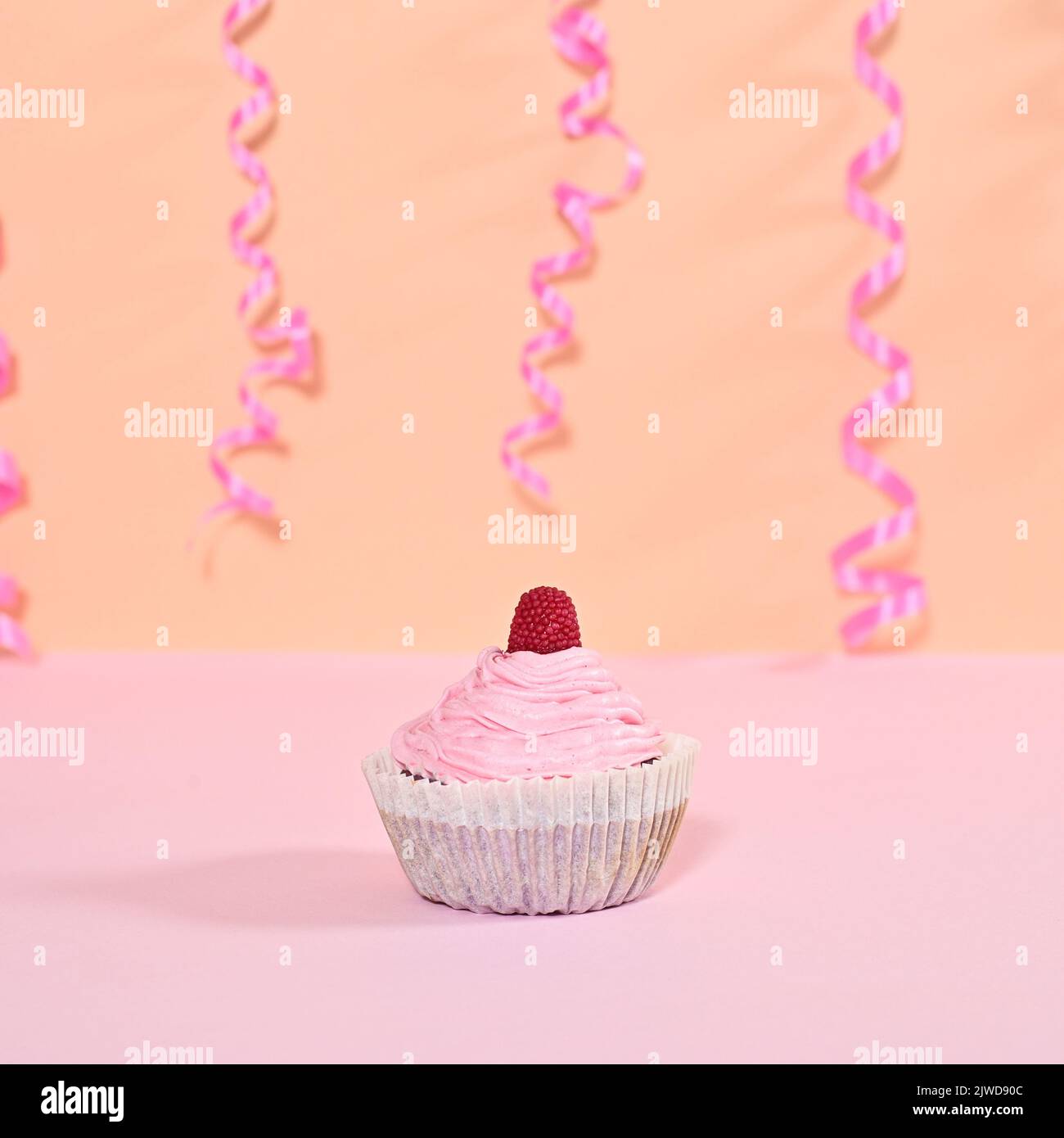 Sweet cup cake with pastel pink cream and raspberry on the top Stock ...