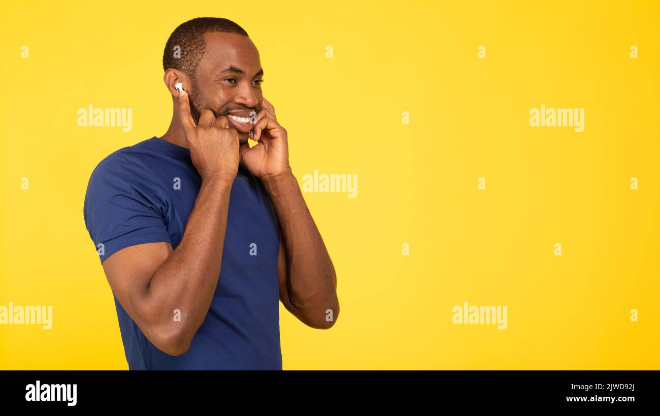 Happy Black Male Listening Music Wearing Earbuds Over Yellow Background Stock Photo - Alamy