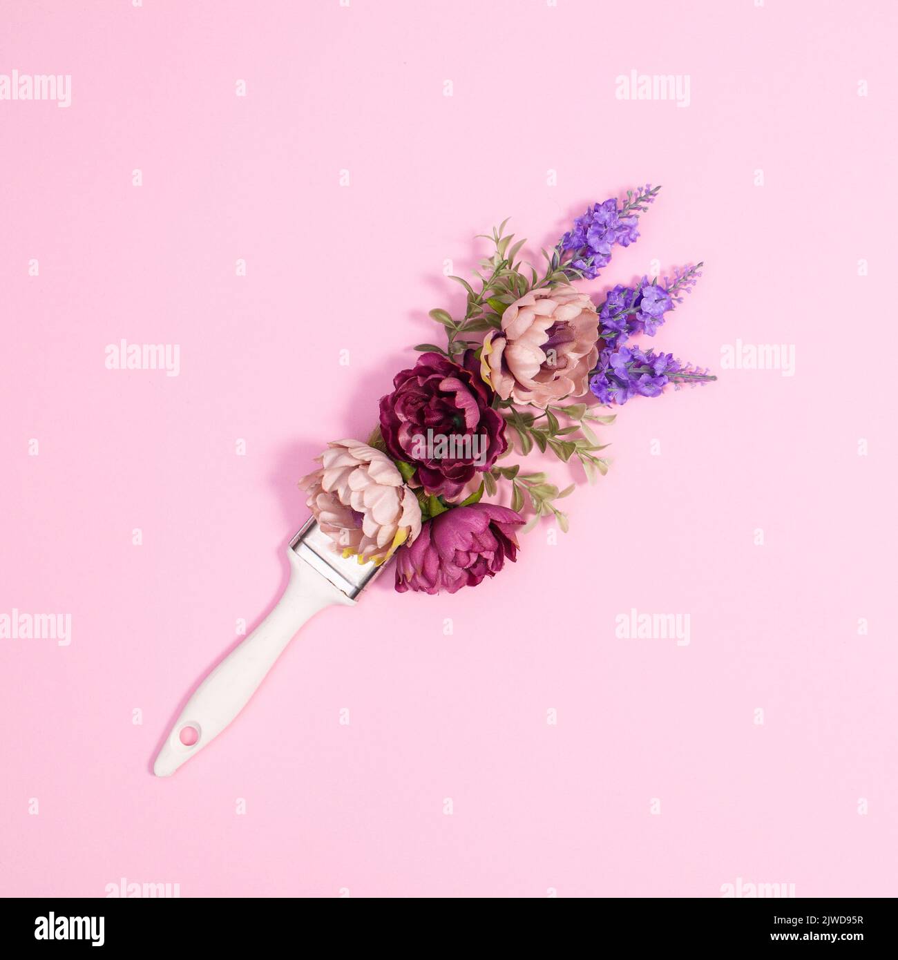 Creative paint brush with spring flowers on pastel pink background ...