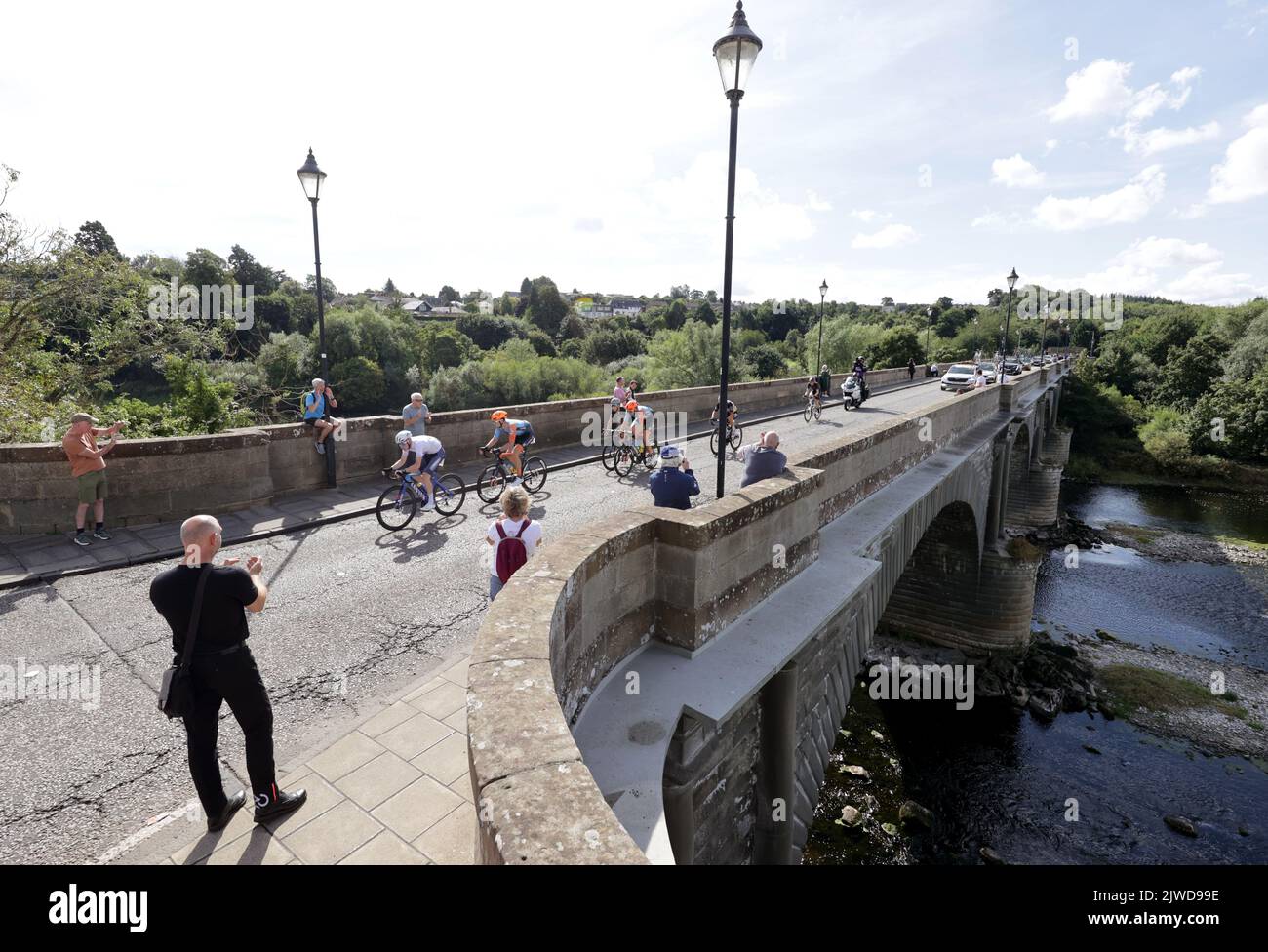 The leading pack rides over Kelso Bridge across the River Tweed at ...
